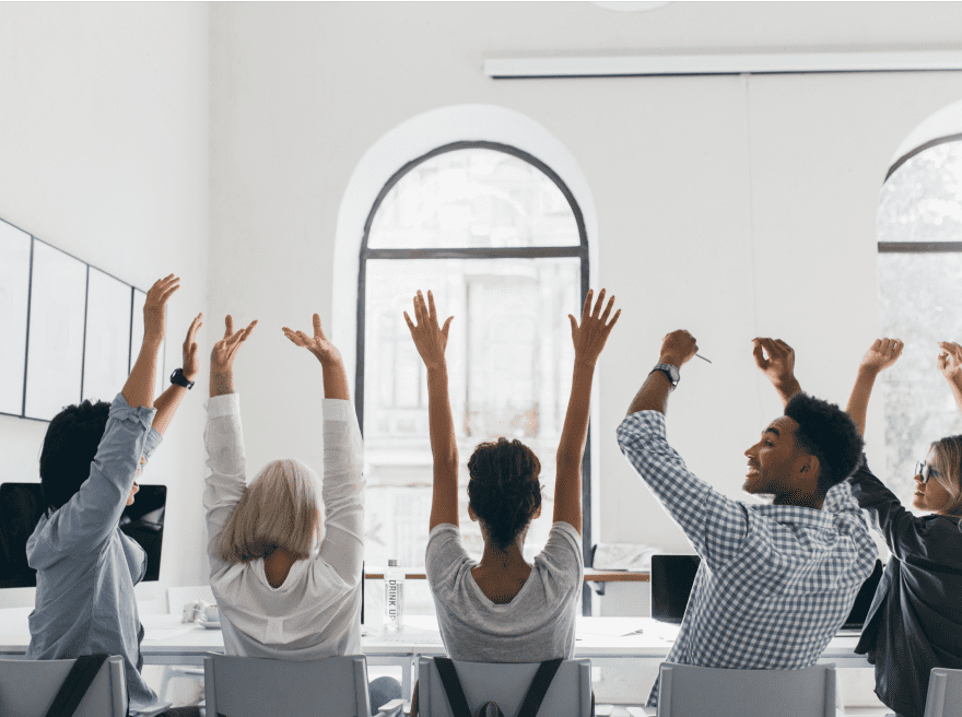 Five people sitting and holding their hands up